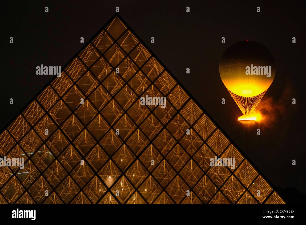 The Olympic Flame rises on a balloon over the Louvre after being lit in ...