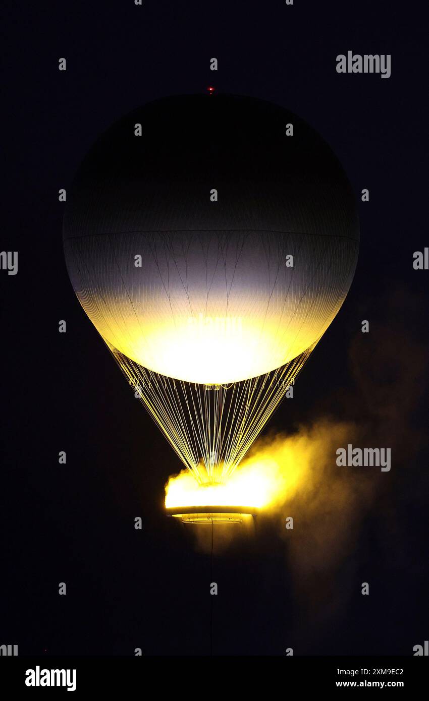 A balloon carrying the Olympic Cauldron rises in the sky during the ...