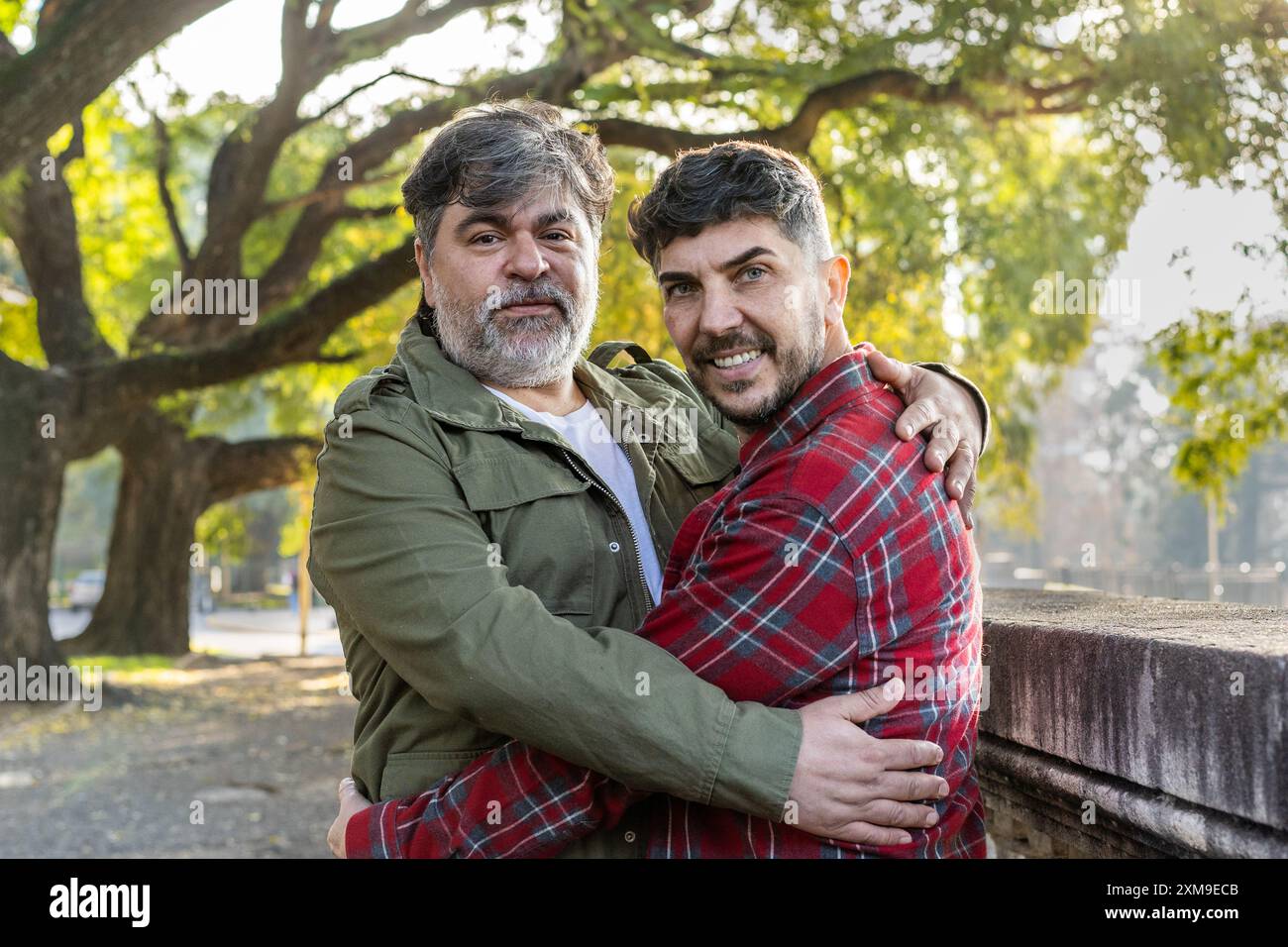 Two married men who are in love are embracing each other while looking ...