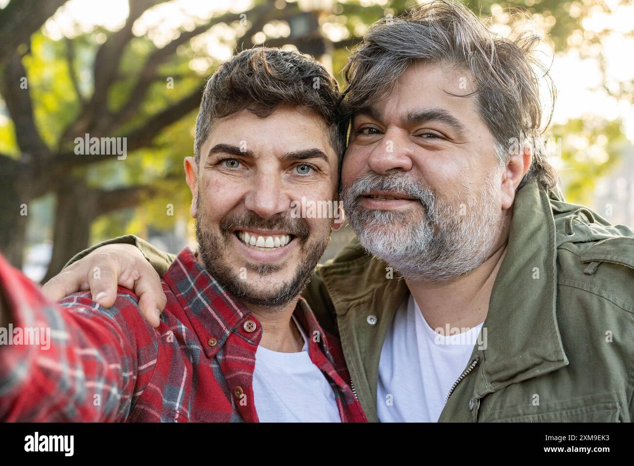 Happy gay couple cuddling hi-res stock photography and images - Alamy