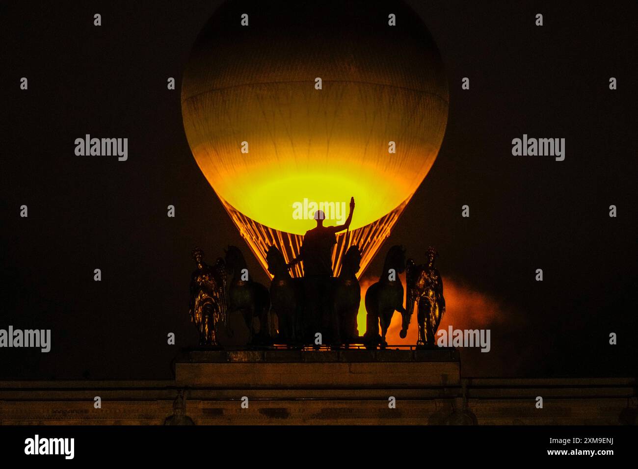 The Olympic Flame rises on a balloon above a statue after being lit in ...