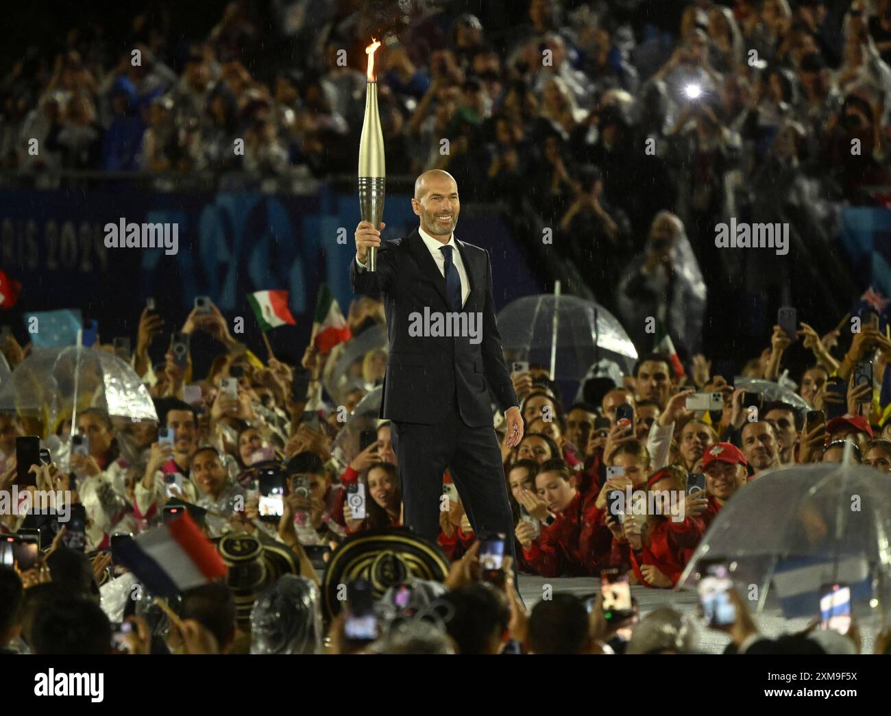 Fomer French footballer Zinedine Zidane holds an Olympic torch during ...