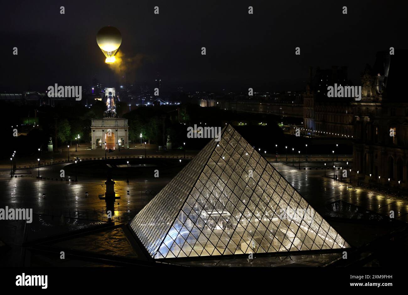 A balloon carrying the Olympic Cauldron rises in the sky over the ...
