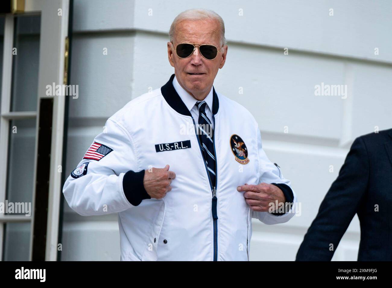 President Joe Biden gestures to his Team USA jacket while exiting the ...