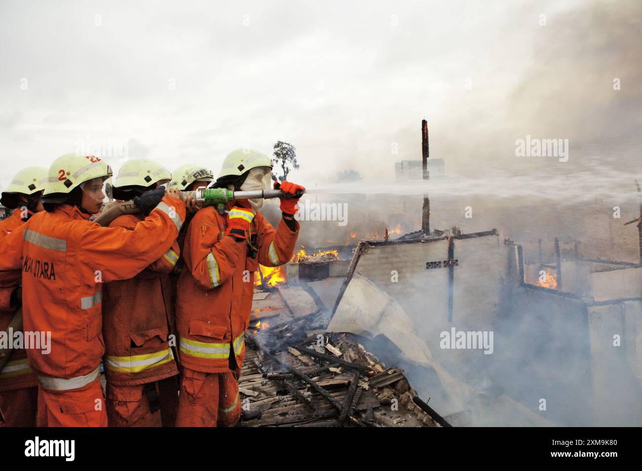 Firefighters performing the cooling phase after a fire accident burned ...