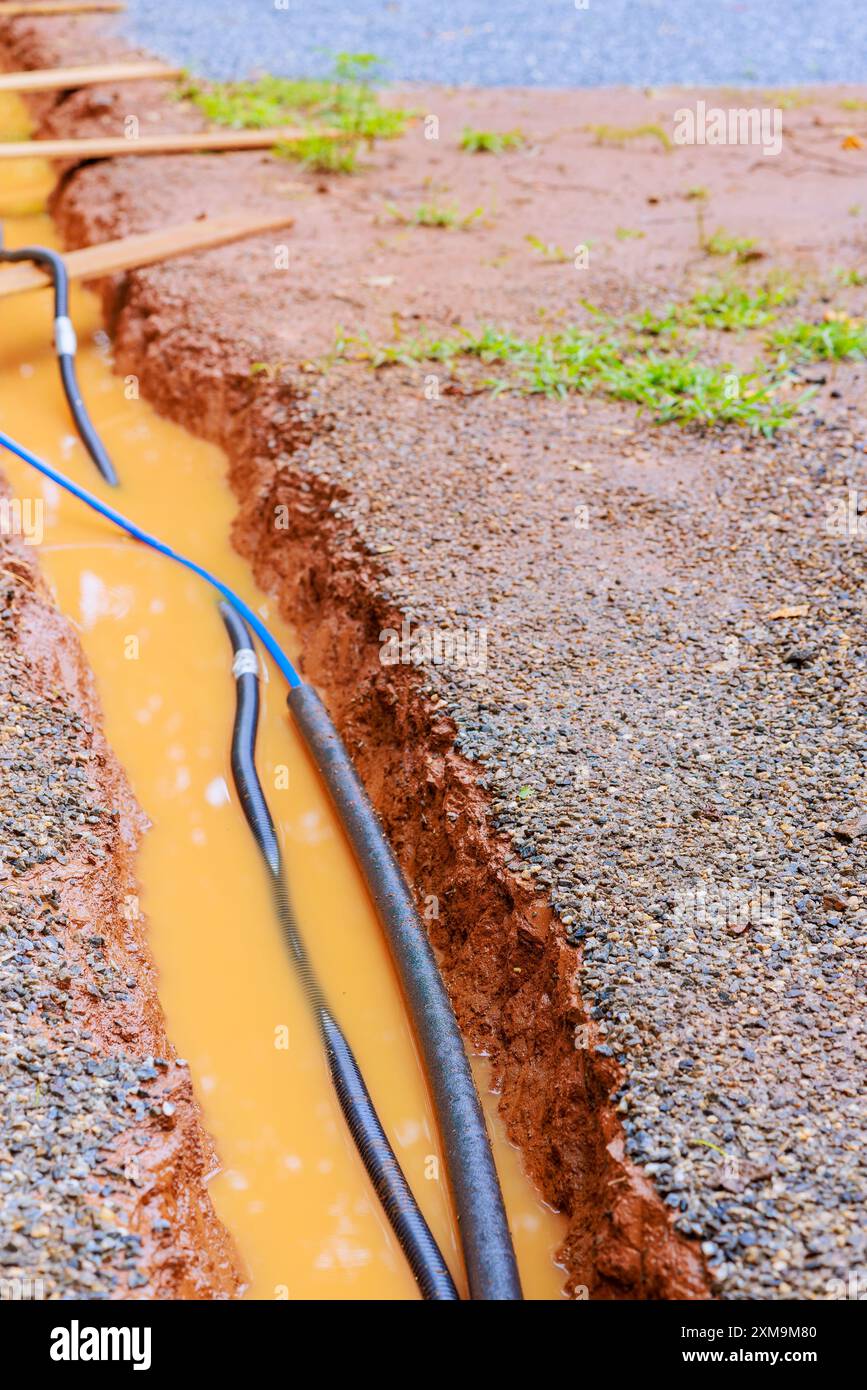 During heavy rain, drainage trench is flood with water for ...