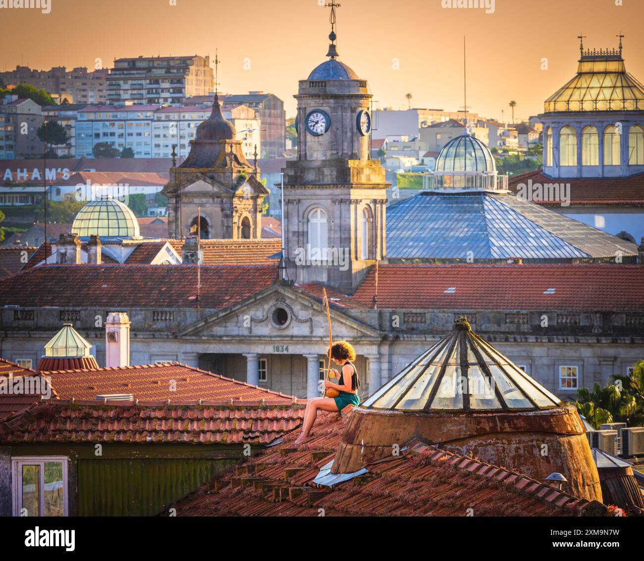 Woman on a Porto, Portugal rooftop, playing the African instrament ...