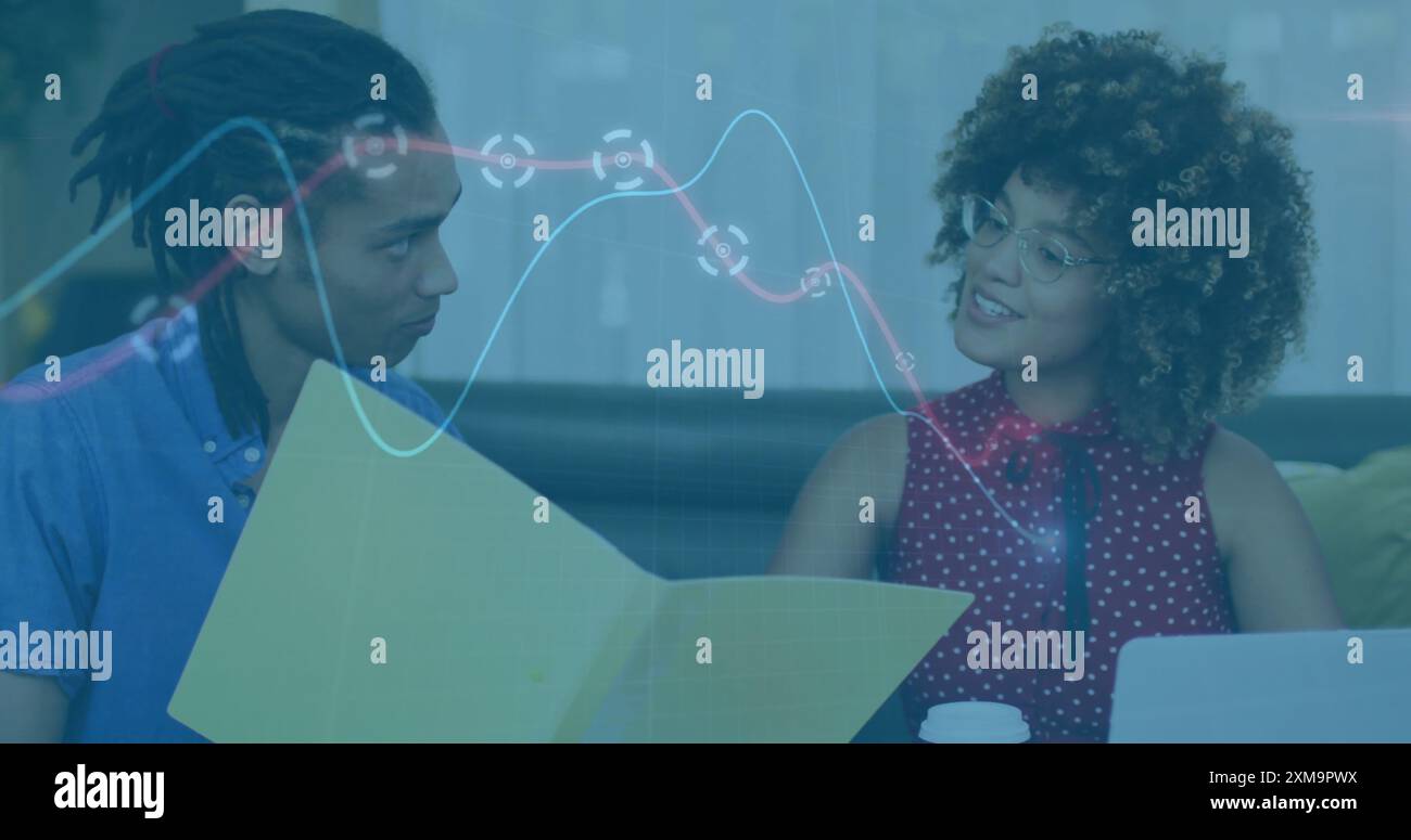 Analyzing data image over two colleagues discussing documents in office ...