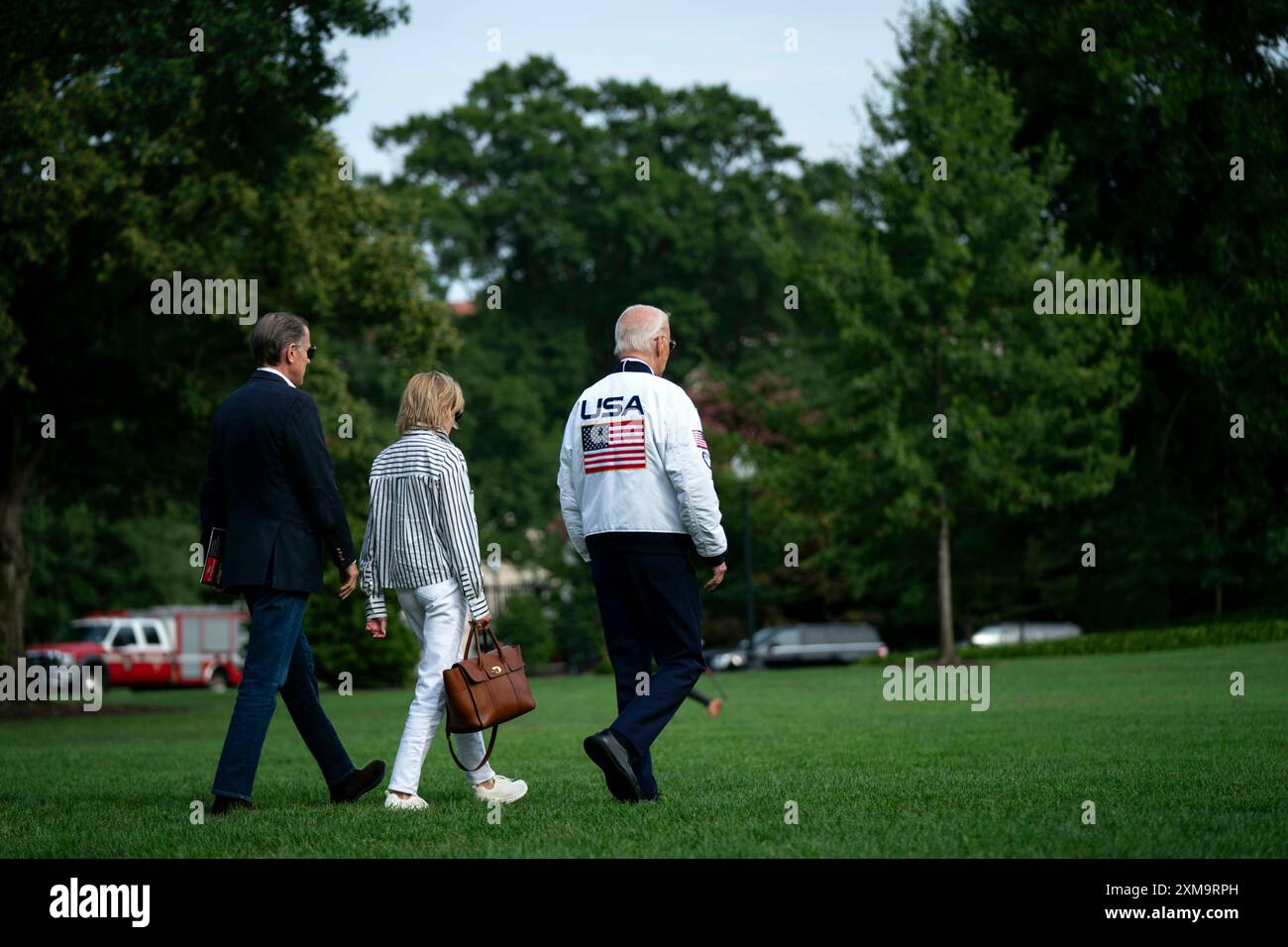 United States President Joe Biden, wearing a Team USA jacket, walks ...