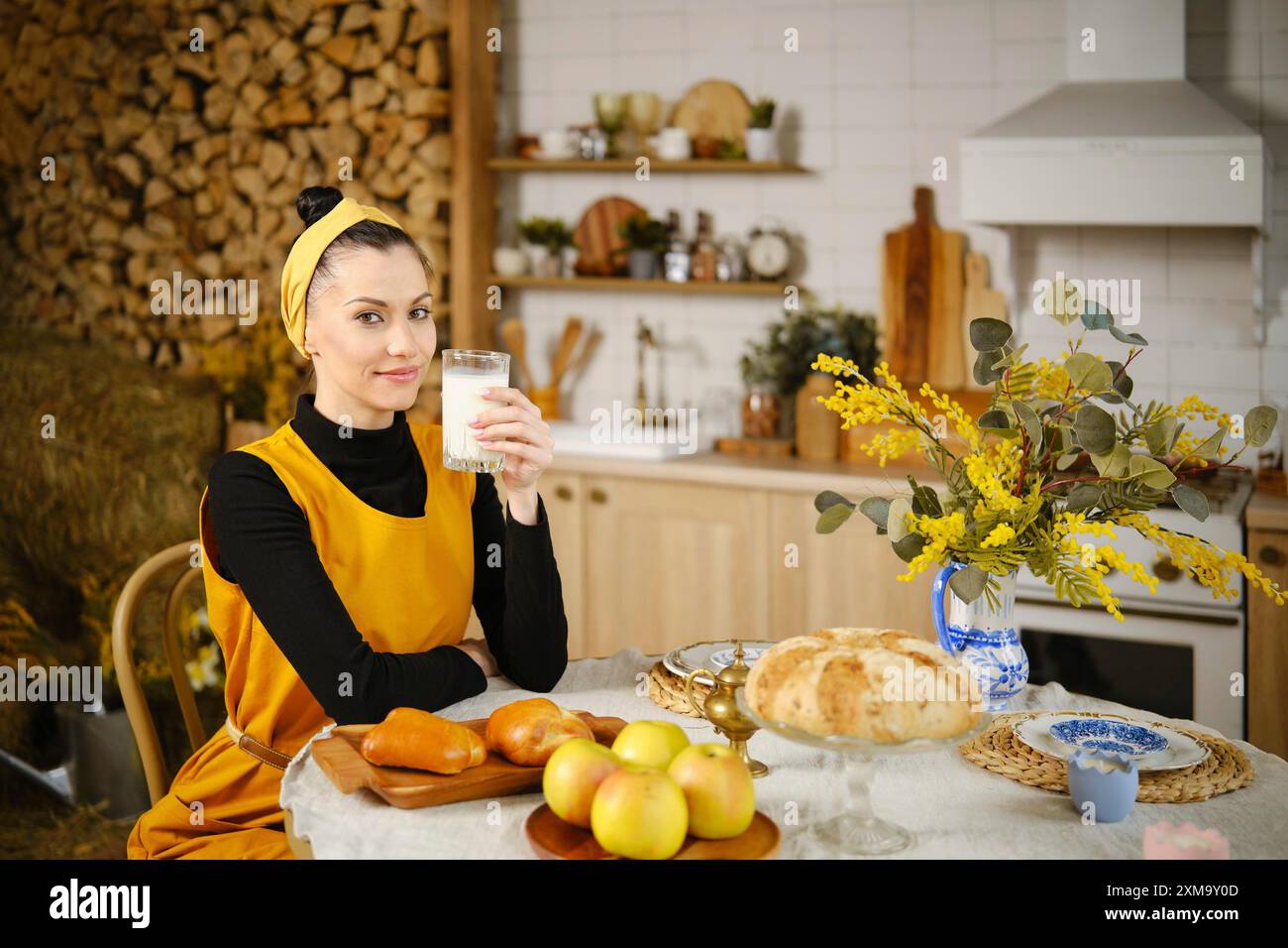 Cute woman has breakfast sitting at the table in the kitchen of her ...