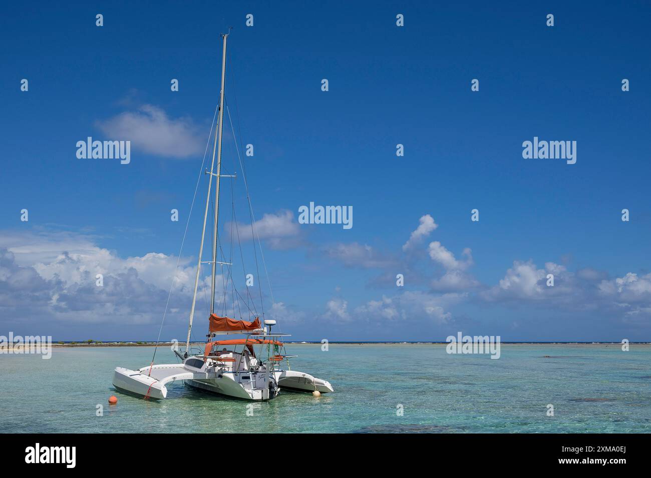 Catamaran moored off the island, Tikehau, Atoll, Tuamotu Archipelago ...