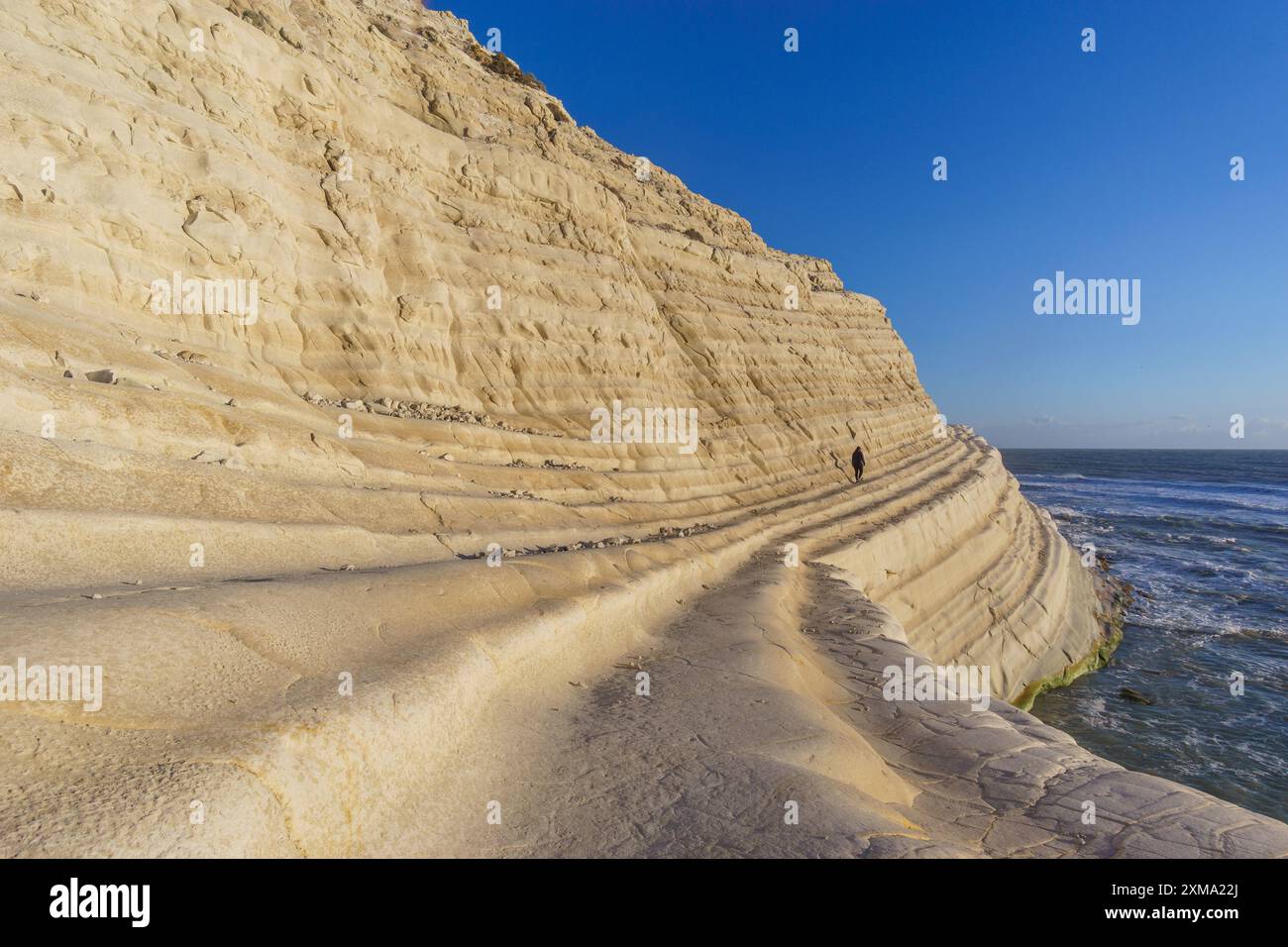 Tourist walking on rock cliff Stairs of the Turks or Scala dei Turchi ...