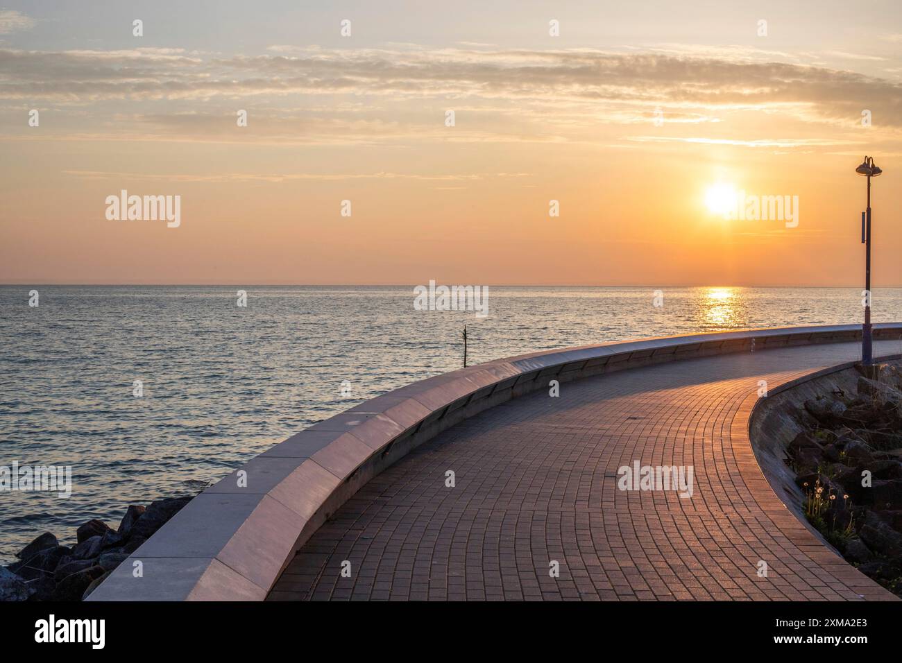 Sunrise on the shore and harbour of a lake in summer. Colourful sky ...