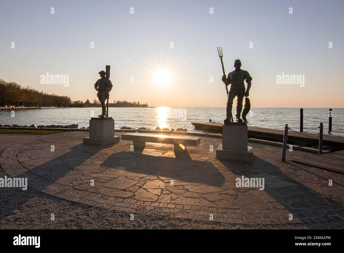 Sunrise on the shore and harbour of a lake in summer. Colourful sky ...