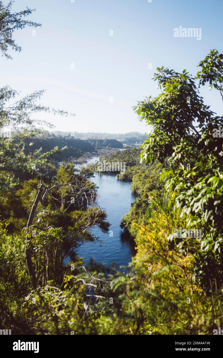 River, surrounded by lush greenery, flows through the valley under a ...