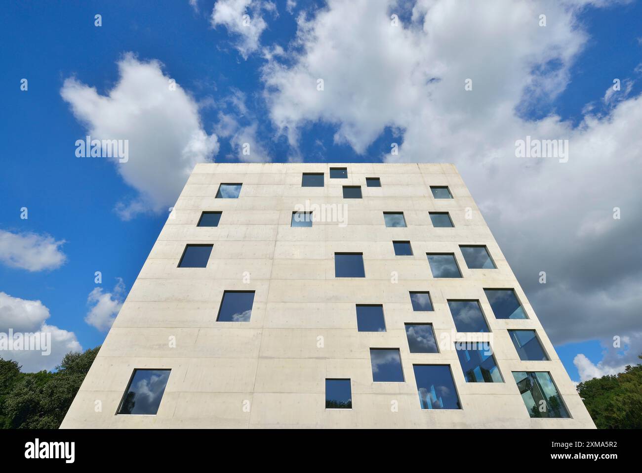 A modern building with numerous square windows in front of a blue sky ...