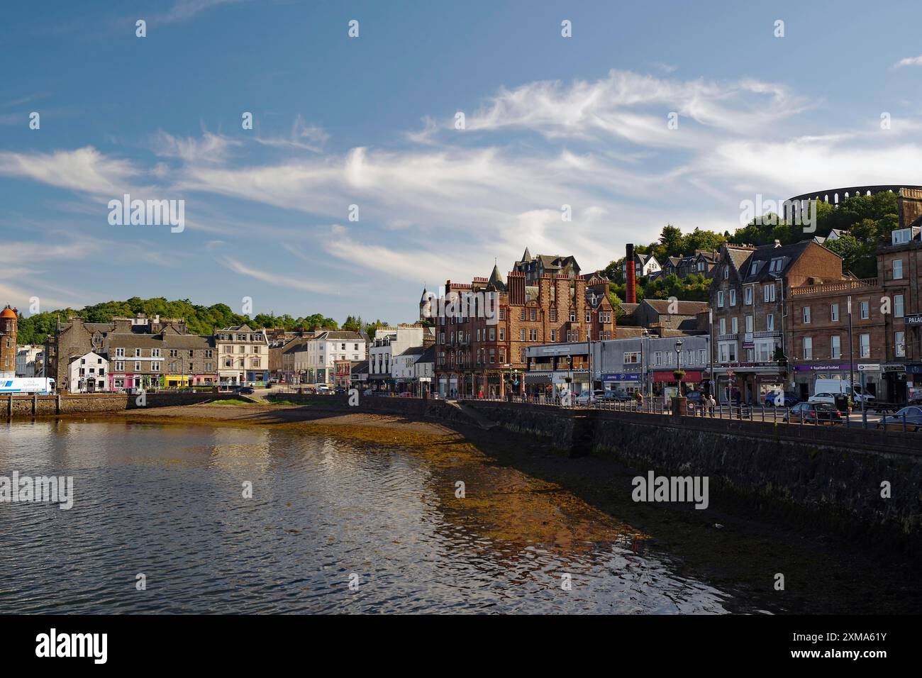 Coastal town with historic buildings along a harbour under a clear sky ...