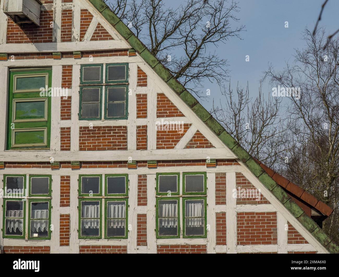 Half-timbered house with green window frames and a tree in the ...