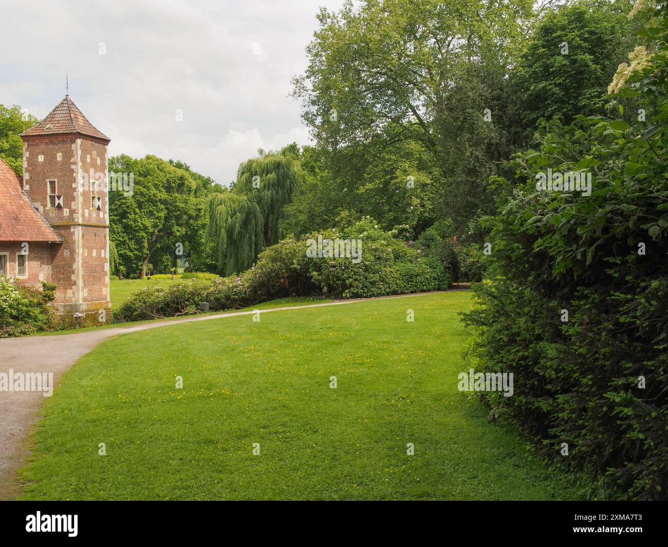 Large castle with a brick tower surrounded by green grass and lush ...