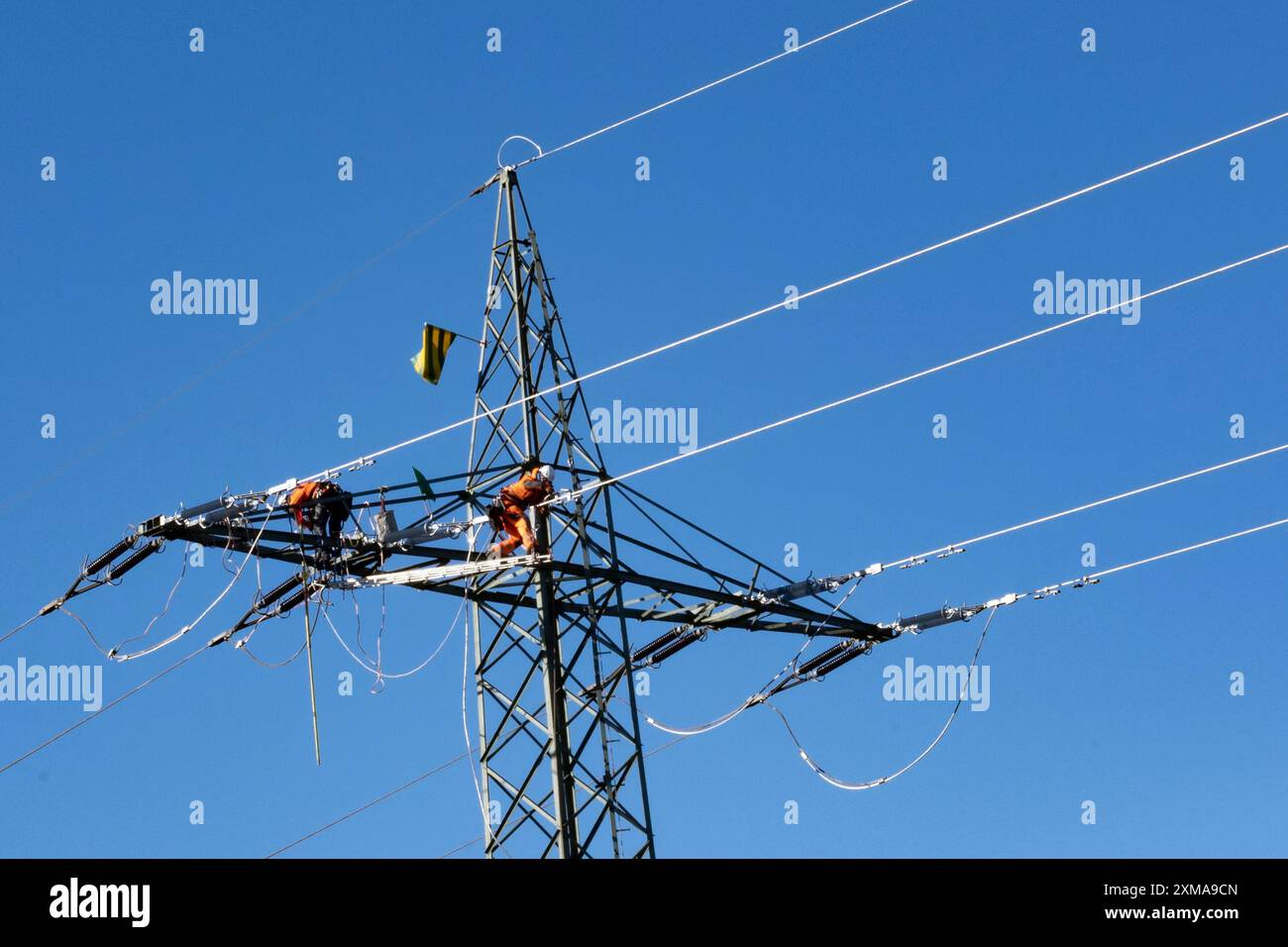 Maintenance work on a high-voltage pylon under a blue sky, Bottrop ...