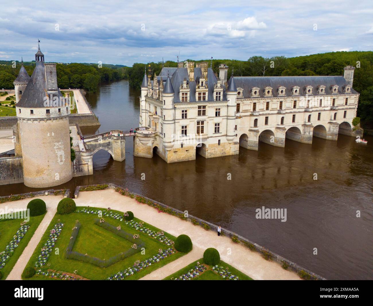 Renaissance castle on a bridge over a river, surrounded by well-tended ...