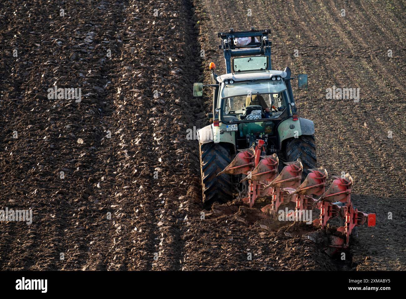 Farmer ploughing a field, tractor with plough, near Neuss, North Rhine ...