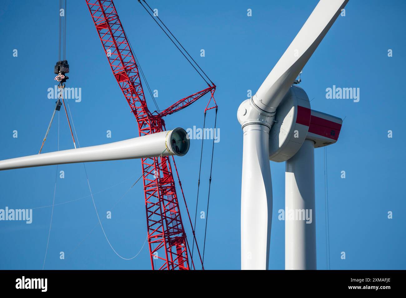 Assembly of a wind turbine, the last rotor blade is being mounted ...