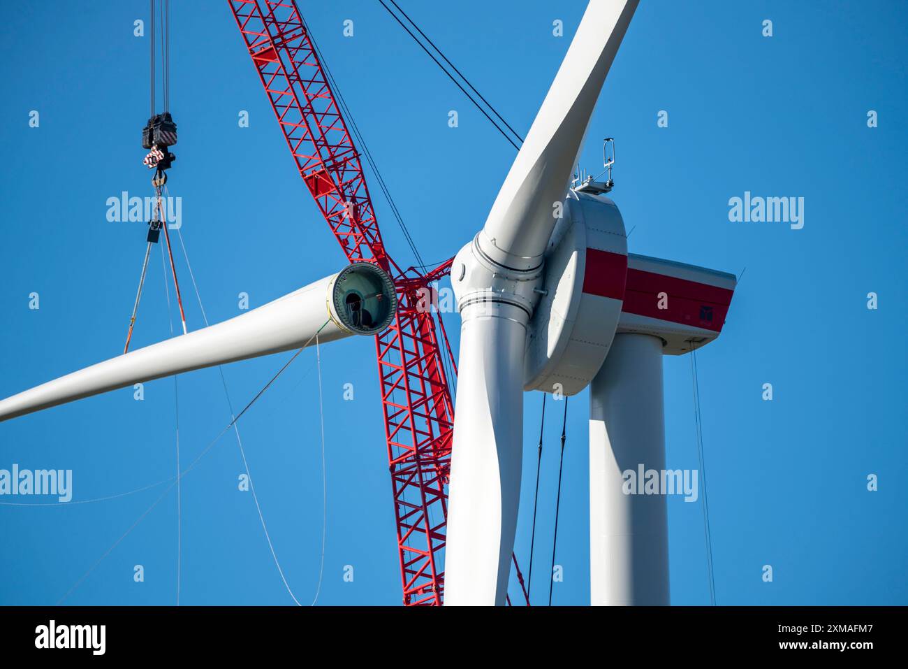 Assembly of a wind turbine, the last rotor blade is being mounted ...