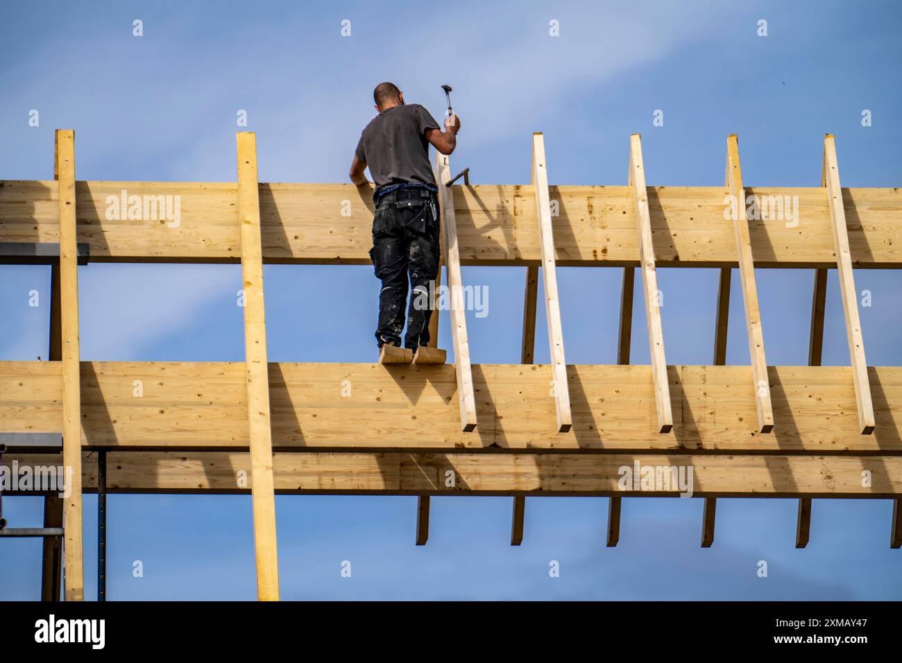 Carpenter, on a roof truss, new construction of a wooden pointed roof ...