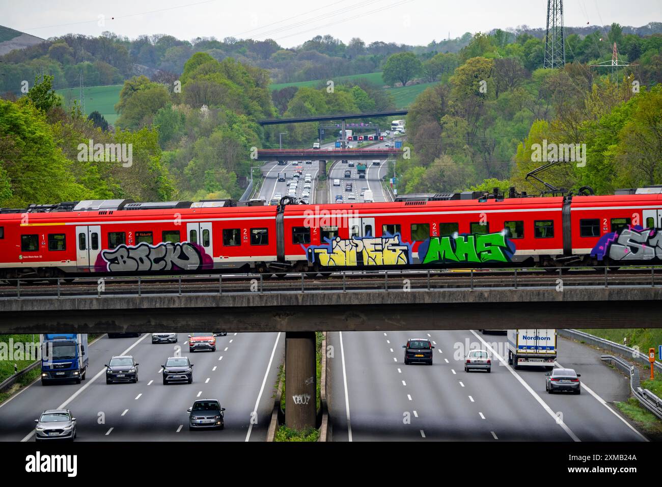 S-Bahn train crossing the motorway A3, traffic on 8 lanes, incl. the ...