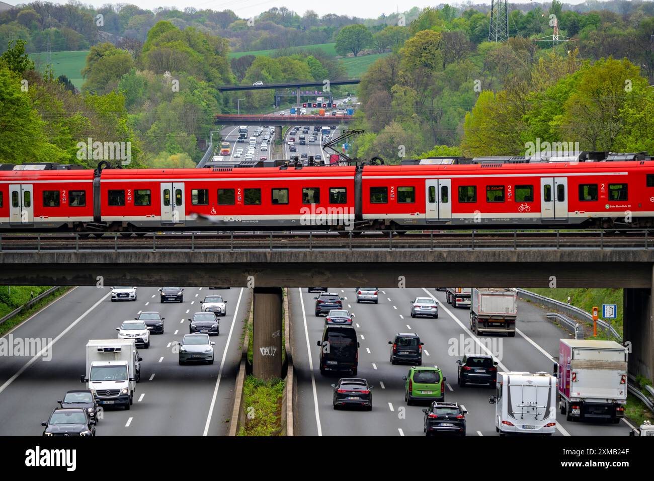 S-Bahn train crossing the motorway A3, traffic on 8 lanes, incl. the ...