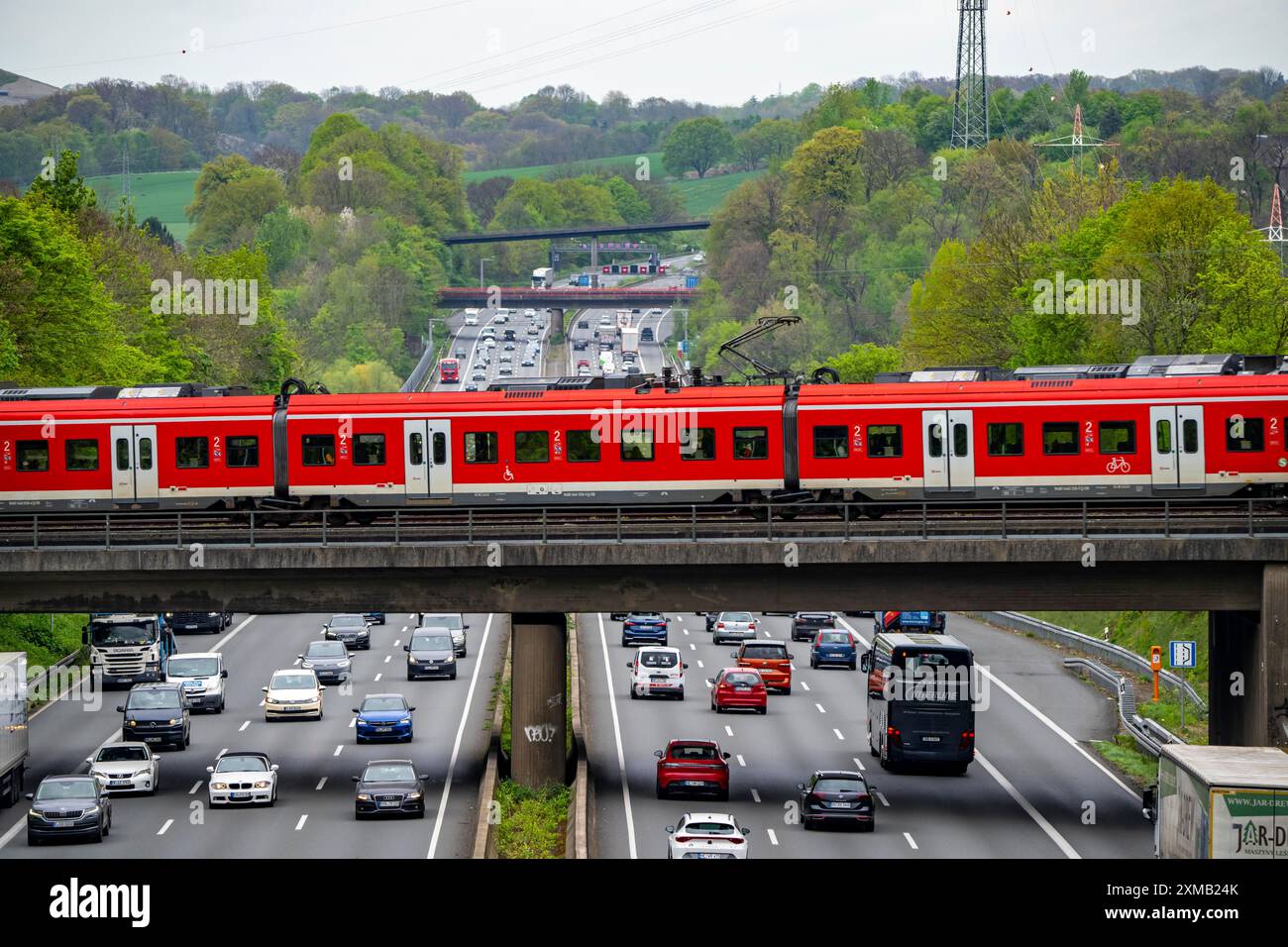 S-Bahn train crossing the motorway A3, traffic on 8 lanes, incl. the ...