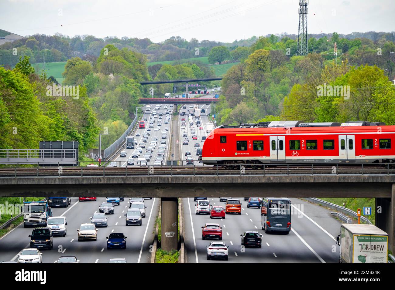 S-Bahn train crossing the motorway A3, traffic on 8 lanes, incl. the ...
