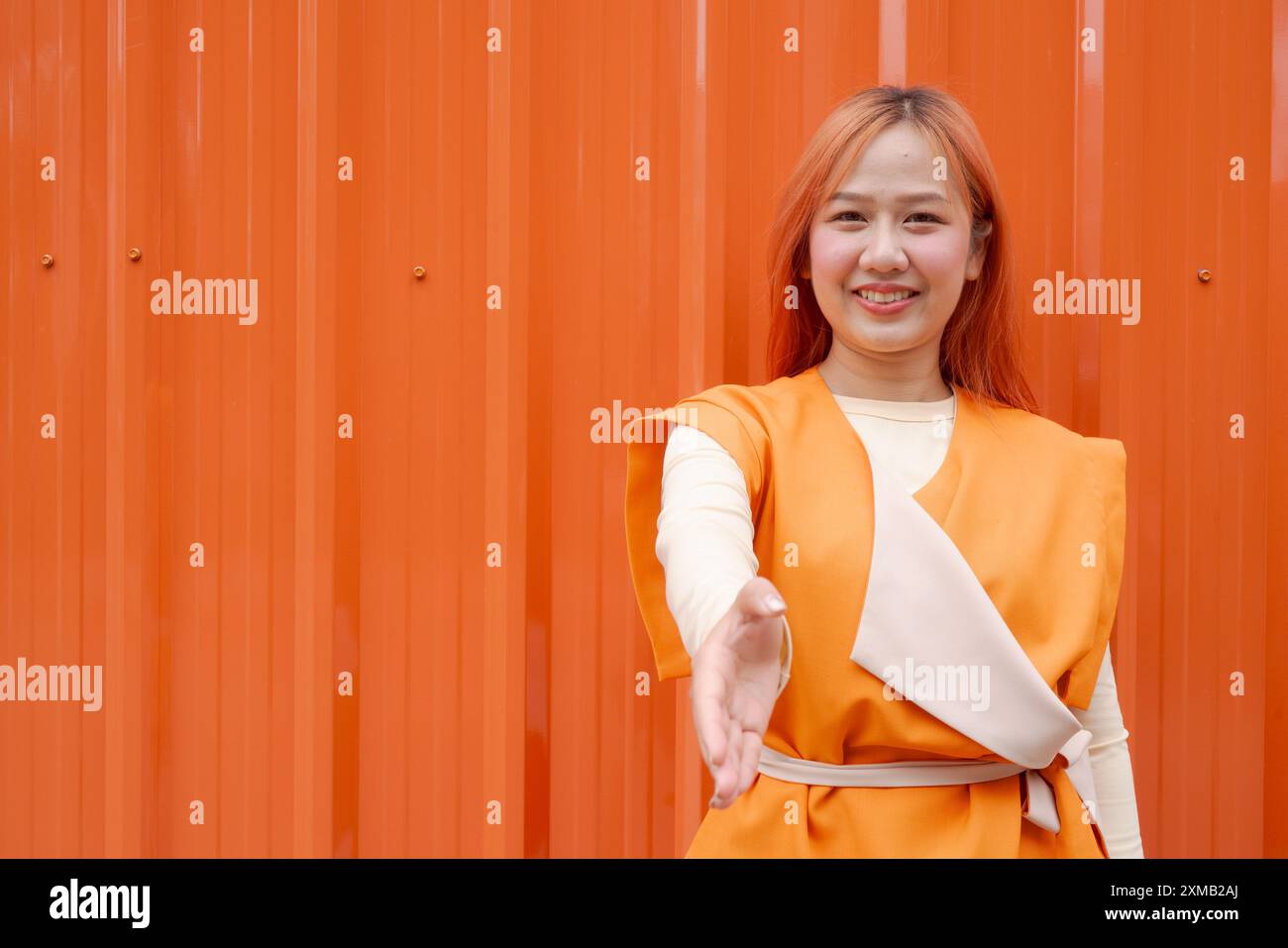 Portrait of Beautiful Asian Woman Offering Handshake Against Orange ...