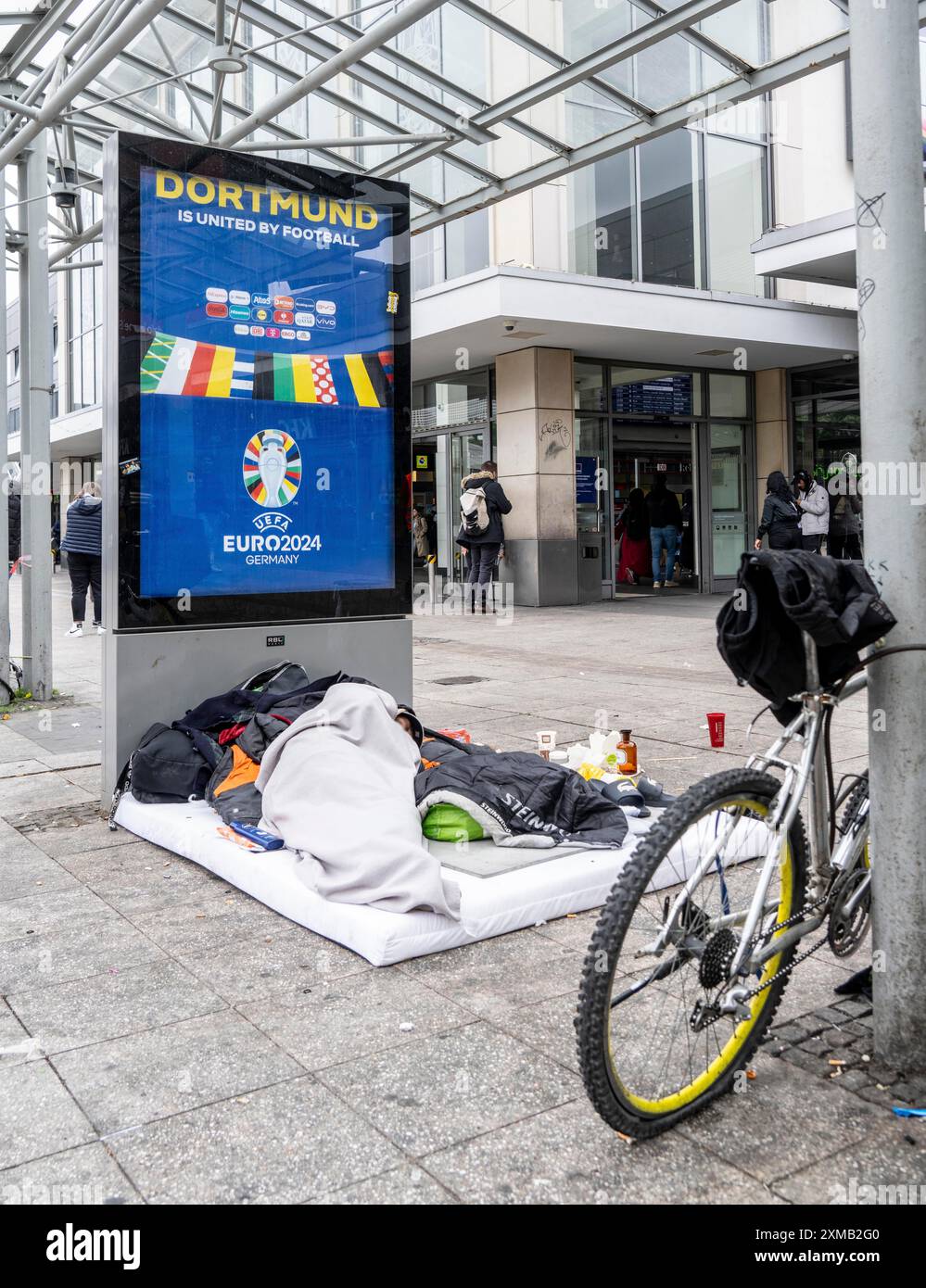 Homeless man sleeping in front of the entrance to Dortmund Central ...