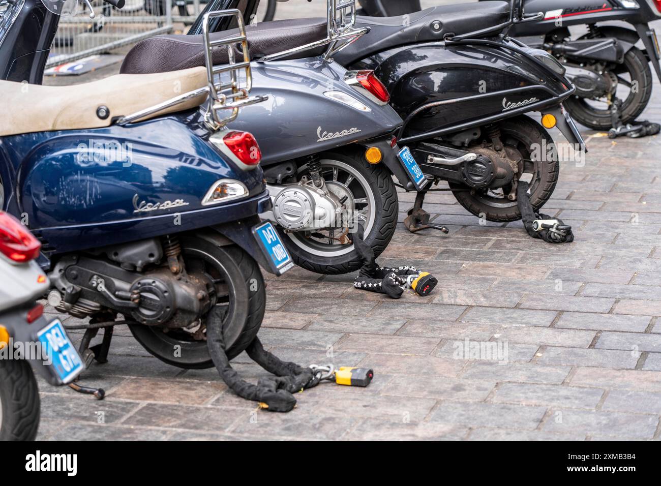 Scooter, locked with thick steel chains, car park in the city centre of ...