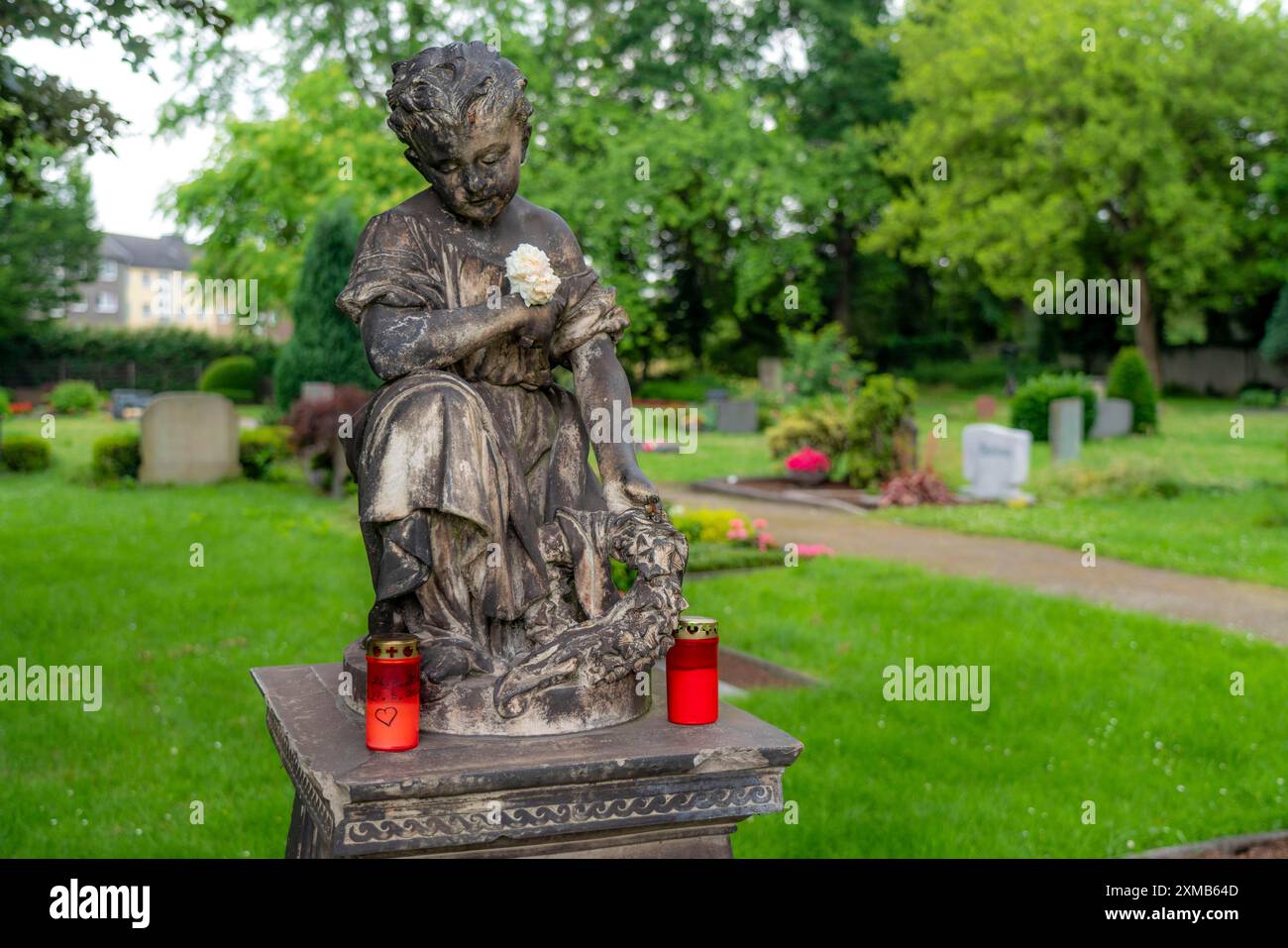 Figure in a cemetery, old gravestone, with flower and grave light ...