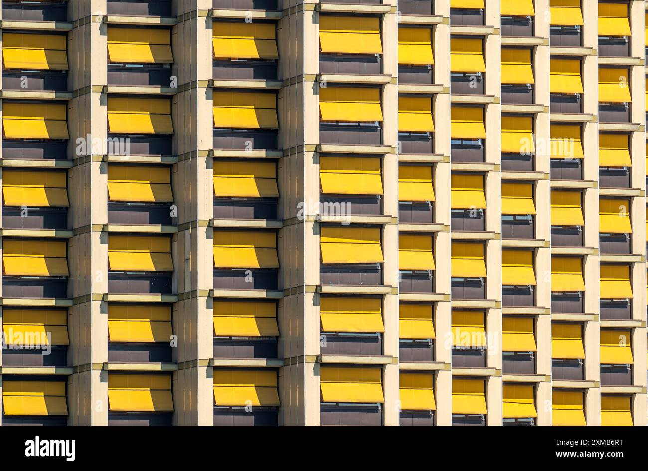 Facade of a building with uniform yellow sun visors, all closed Stock ...