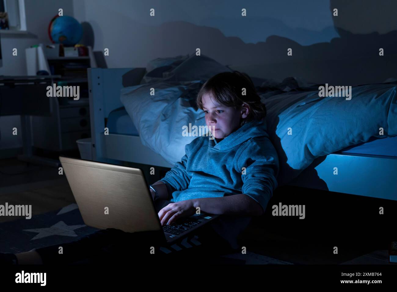 Boy, at home on the computer, laptop, in the children's room, playing a ...