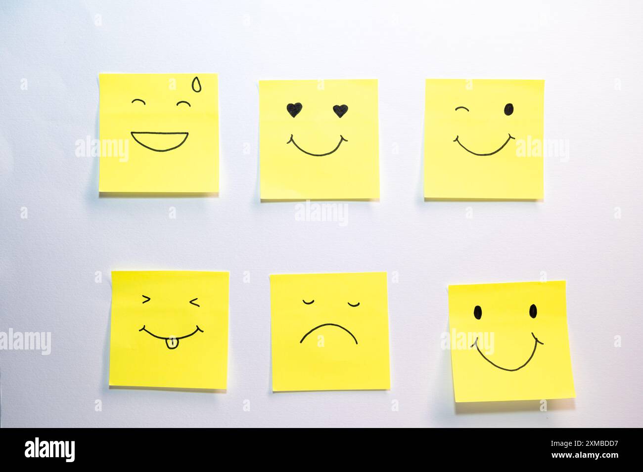 A collection of yellow sticky notes with different facial expressions ...