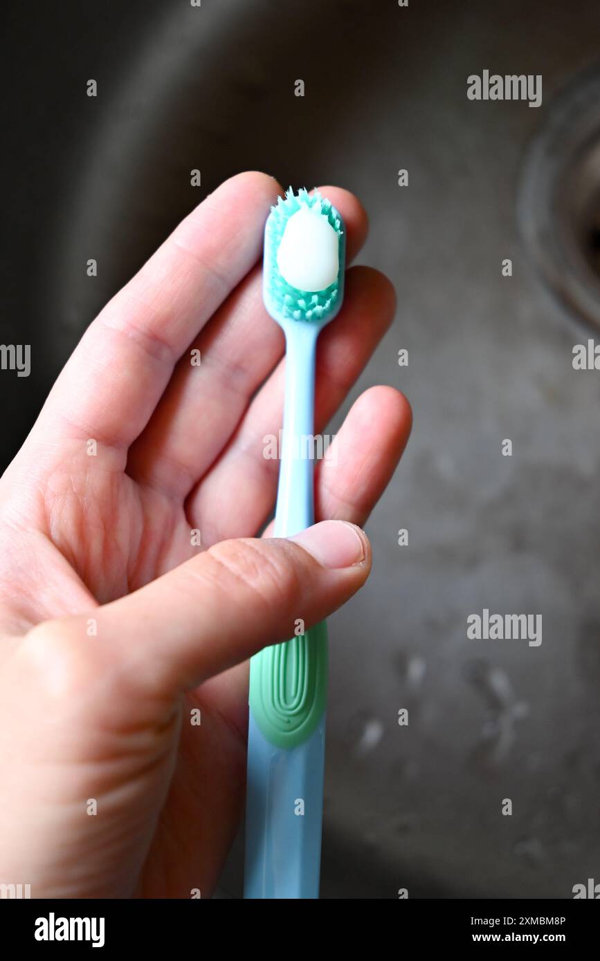 a blue toothbrush with white toothpaste Stock Photo - Alamy