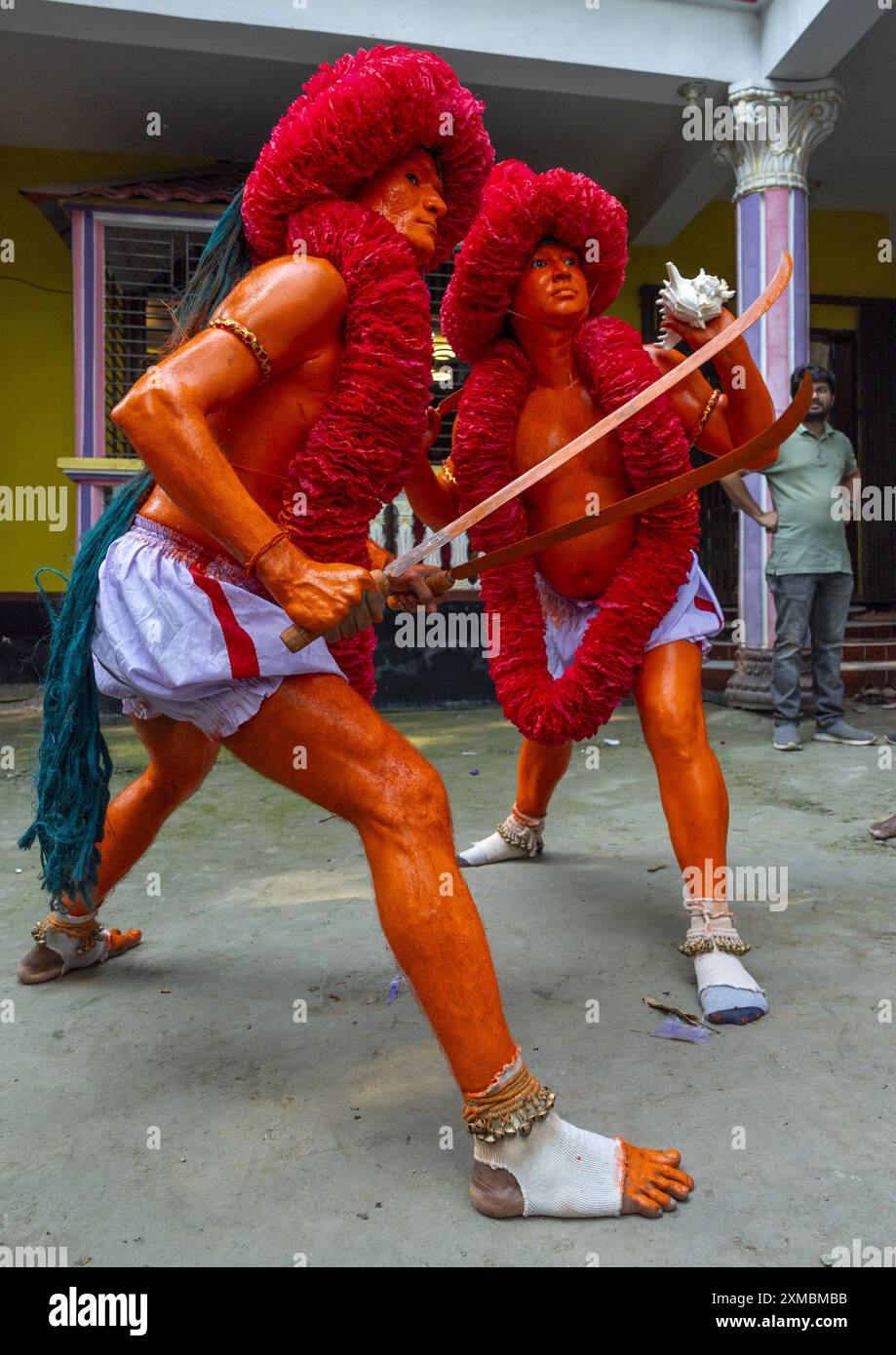Hindu devotees covered with orange color holding swords at Lal Kach ...