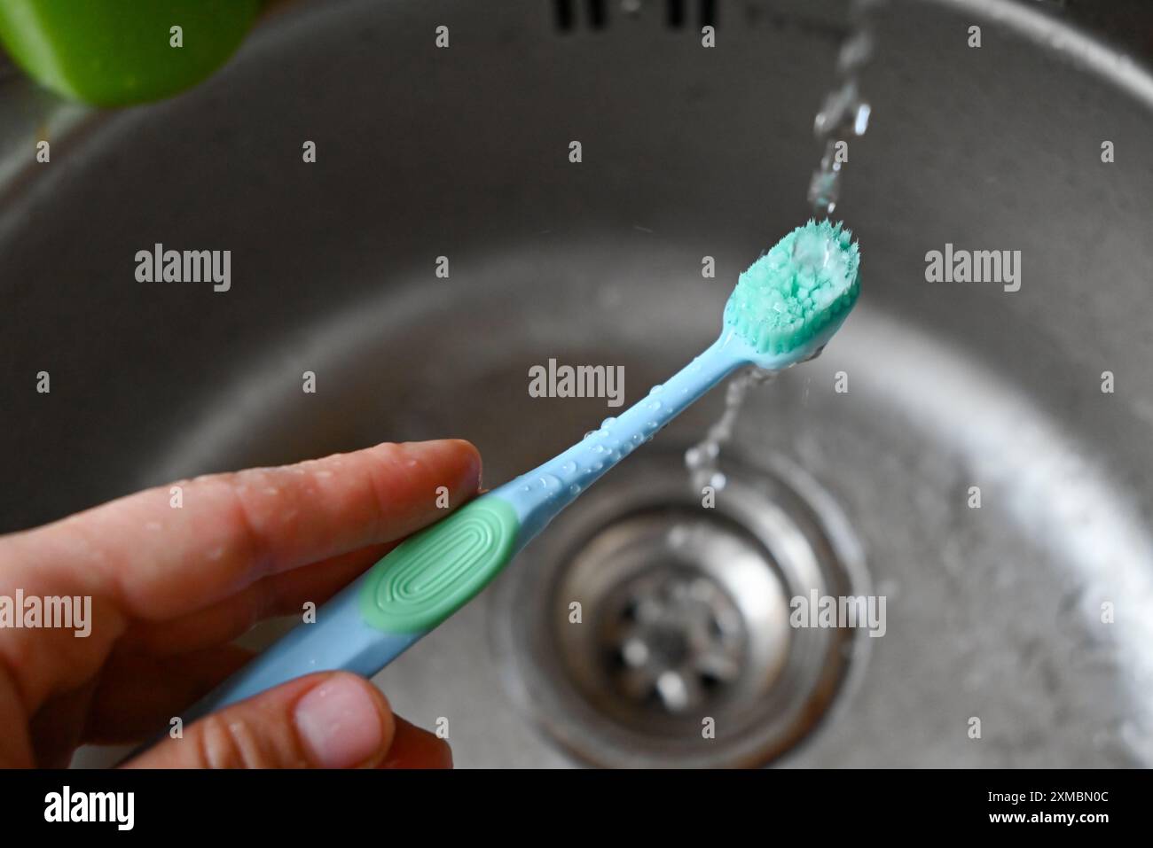 a toothbrush is being held by someone holding a water sprinkler Stock ...