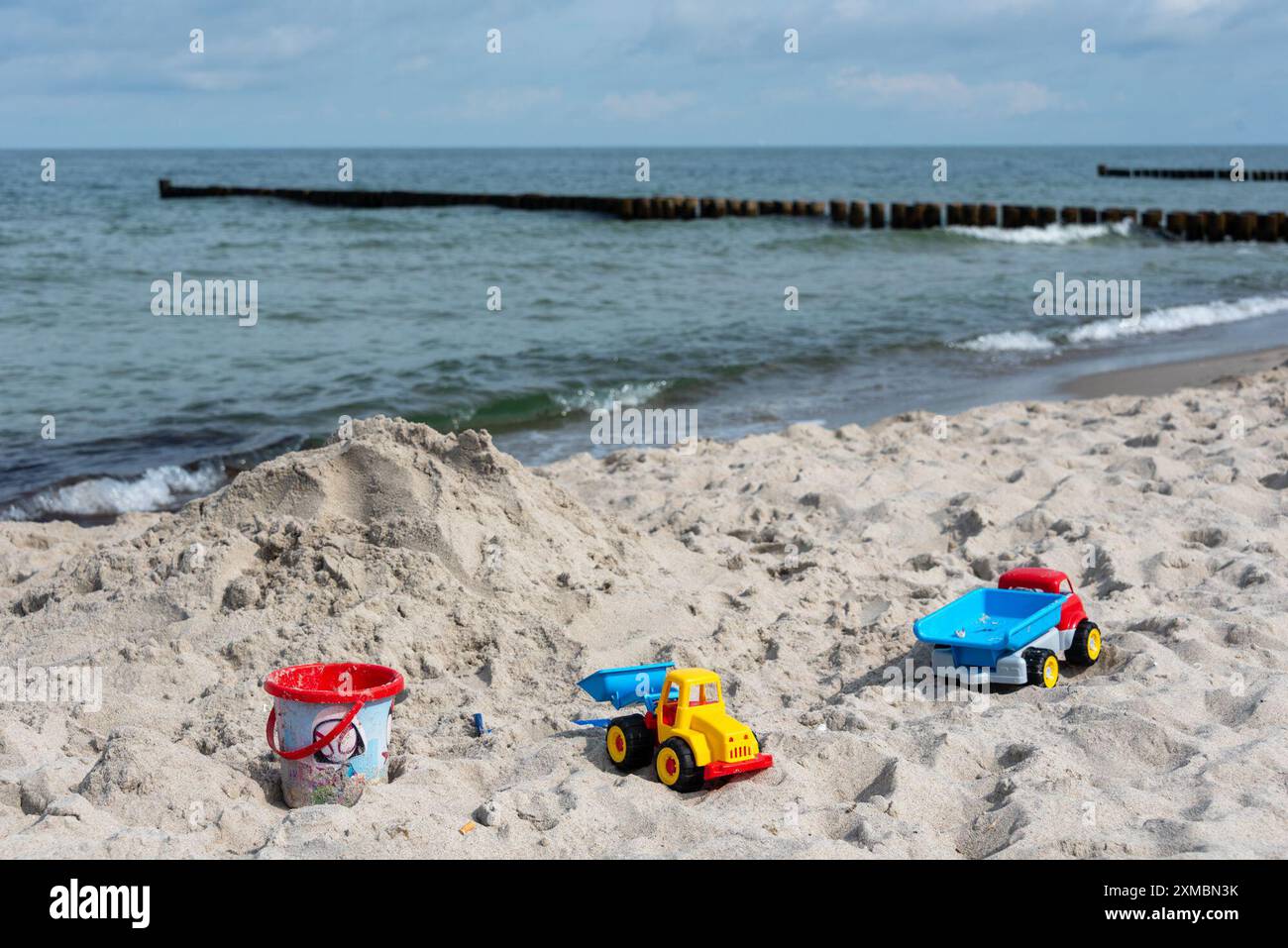 Ahrenshoop, Germany. 27th July, 2024. A toy excavator, a sand bucket ...