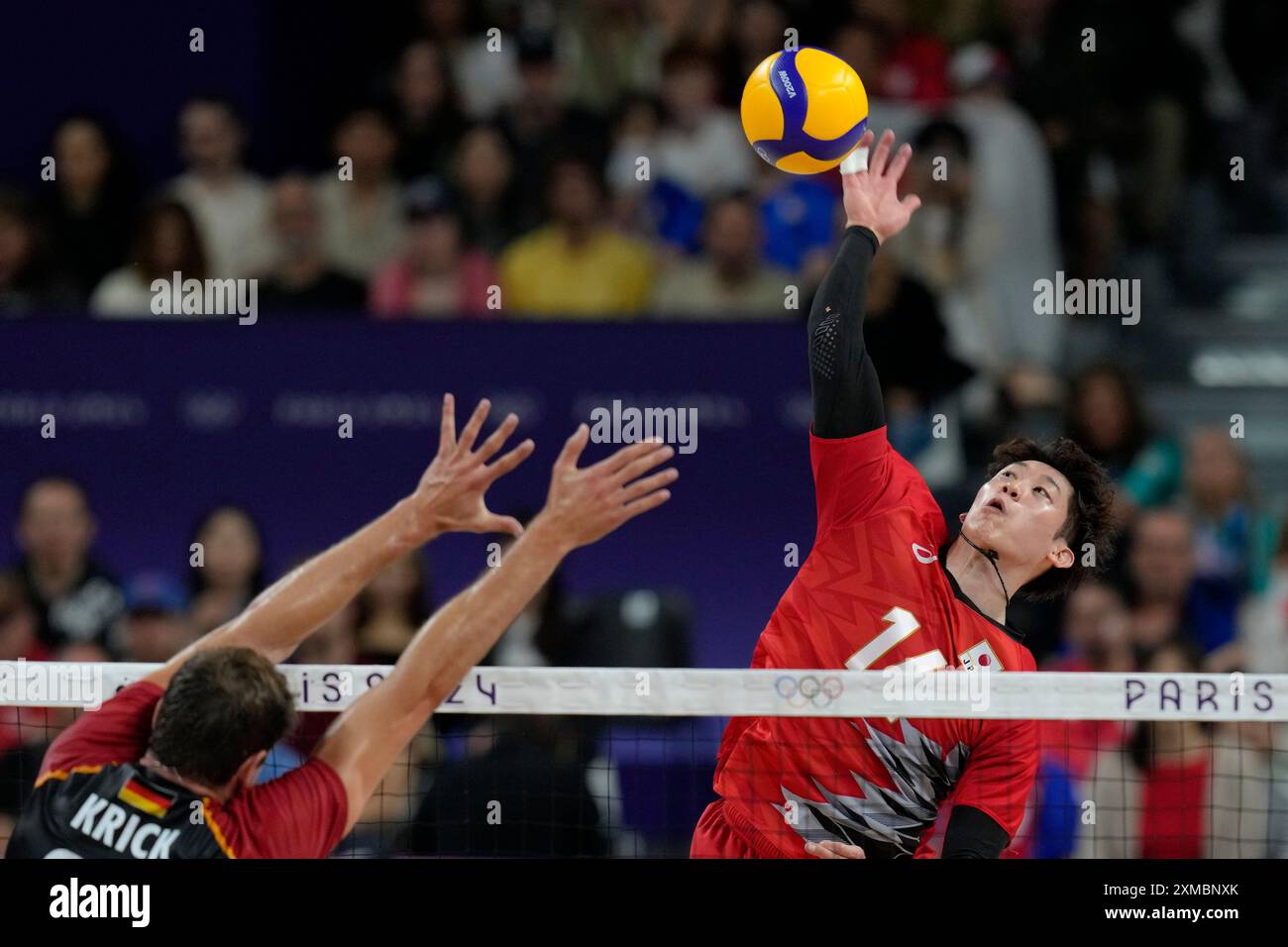 Yuki Ishikawa, of Japan, right, spikes a ball against Germany, during ...