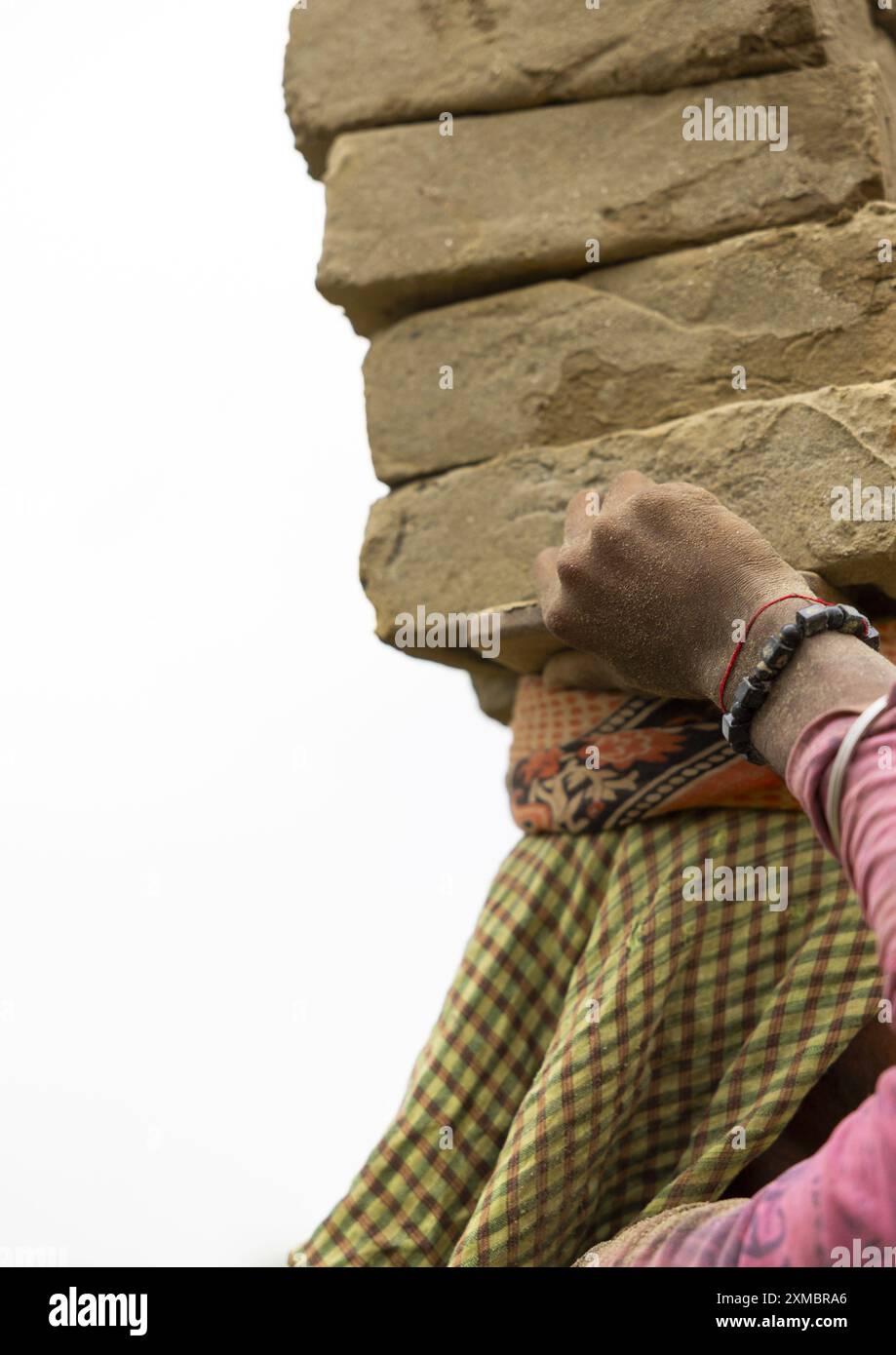 A bangladeshi woman carrying bricks on her head at a brick factory ...