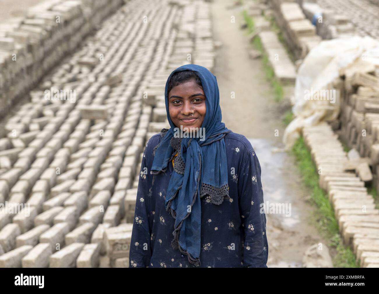 Portrait of a smiling bangladeshi female worker in a brick factory ...