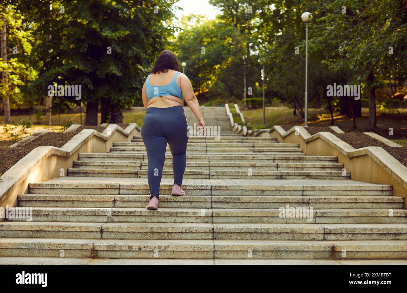 Overweight happy smiling fat woman running up the stairs in the city ...