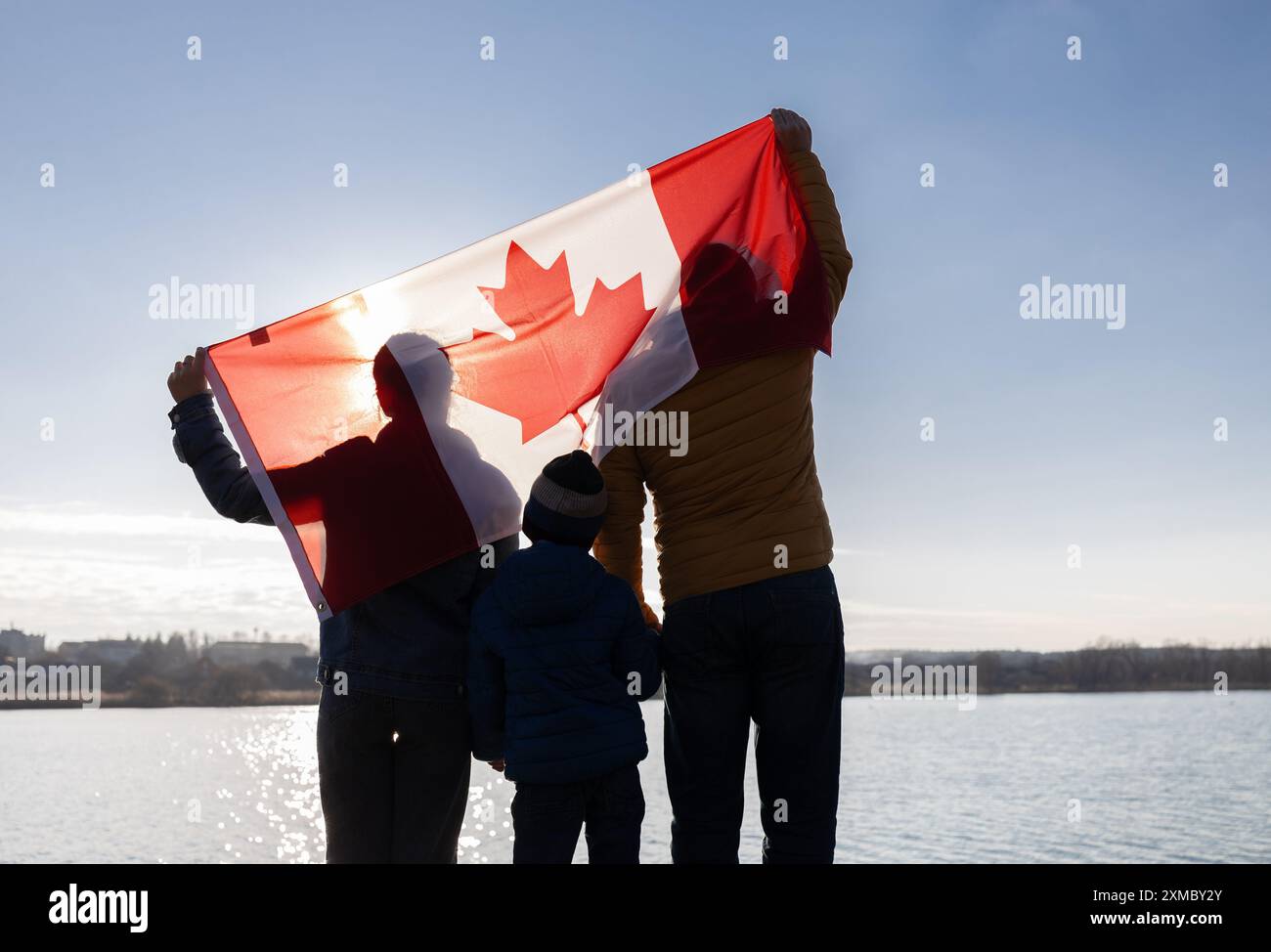 the family holds the Canadian flag behind their backs against the ...