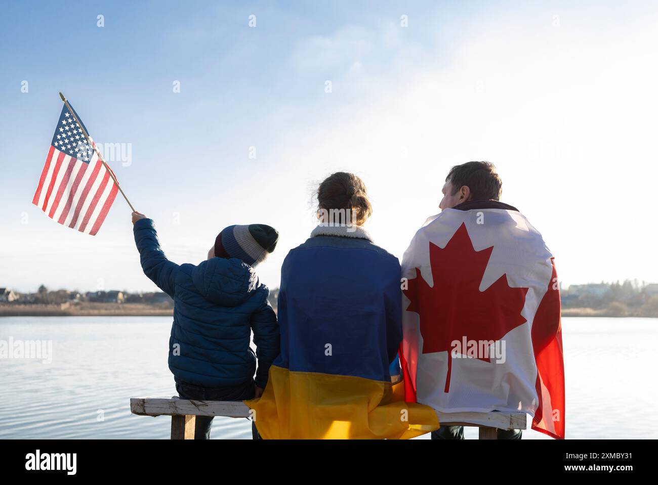 family with Canadian flag, Ukrainian and American flags outdoors ...